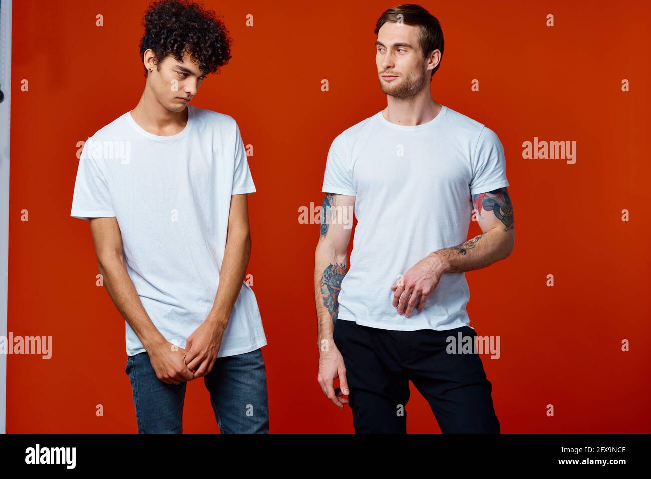 two man in white t-shirts communication friendship red background Stock ...