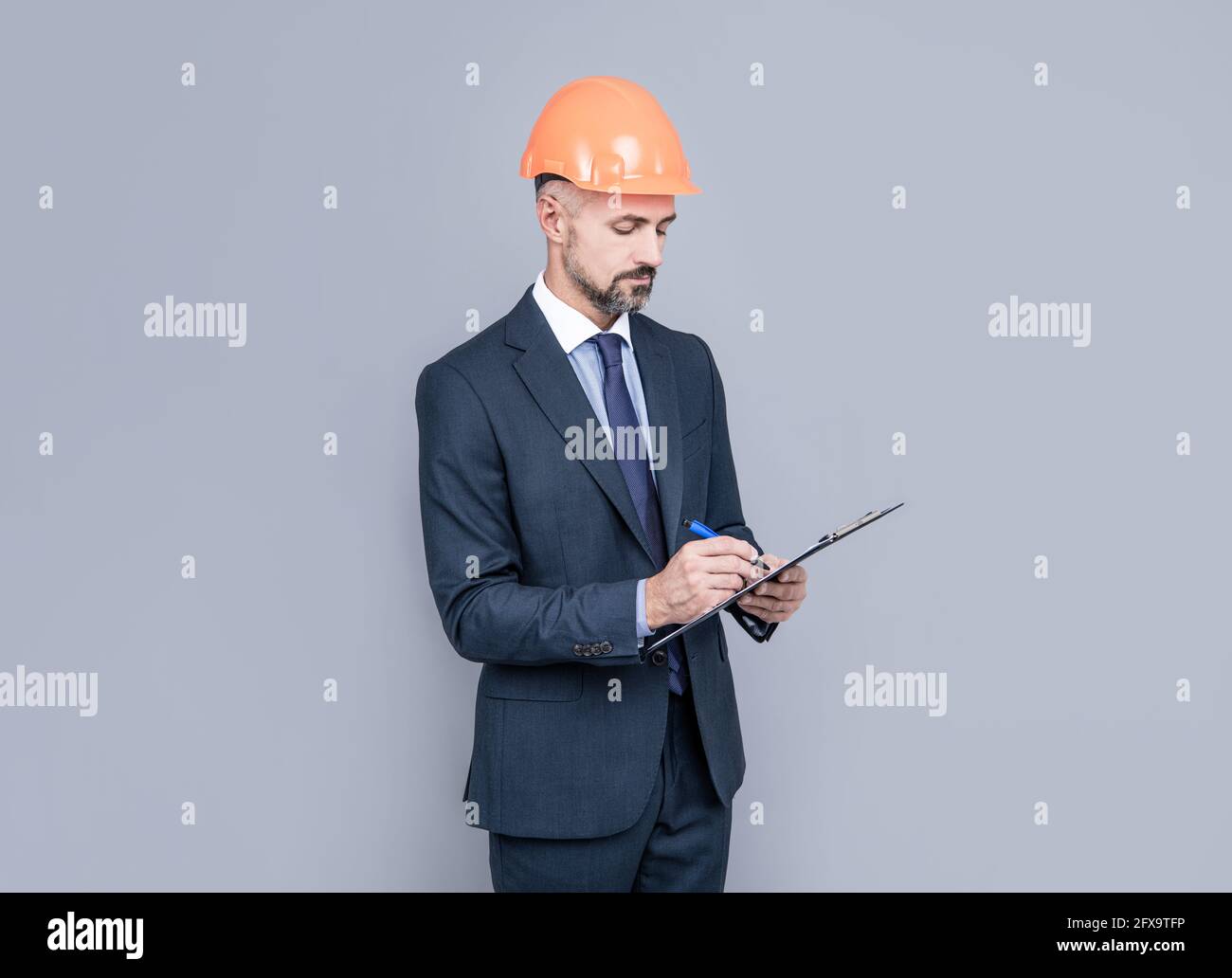 architect man in businesslike suit and hardhat making notes, project ...