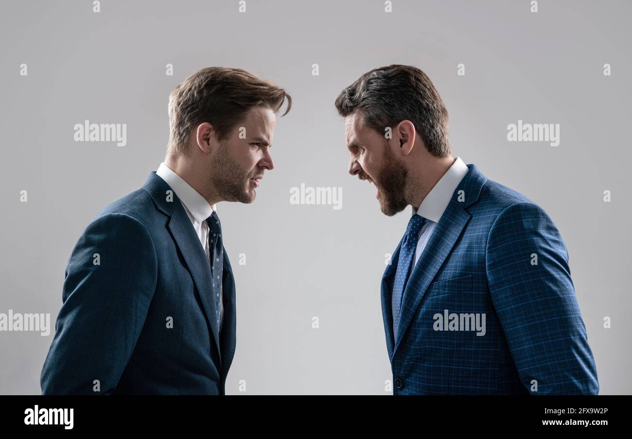 two angry businessmen shouting face to face have business competition ...
