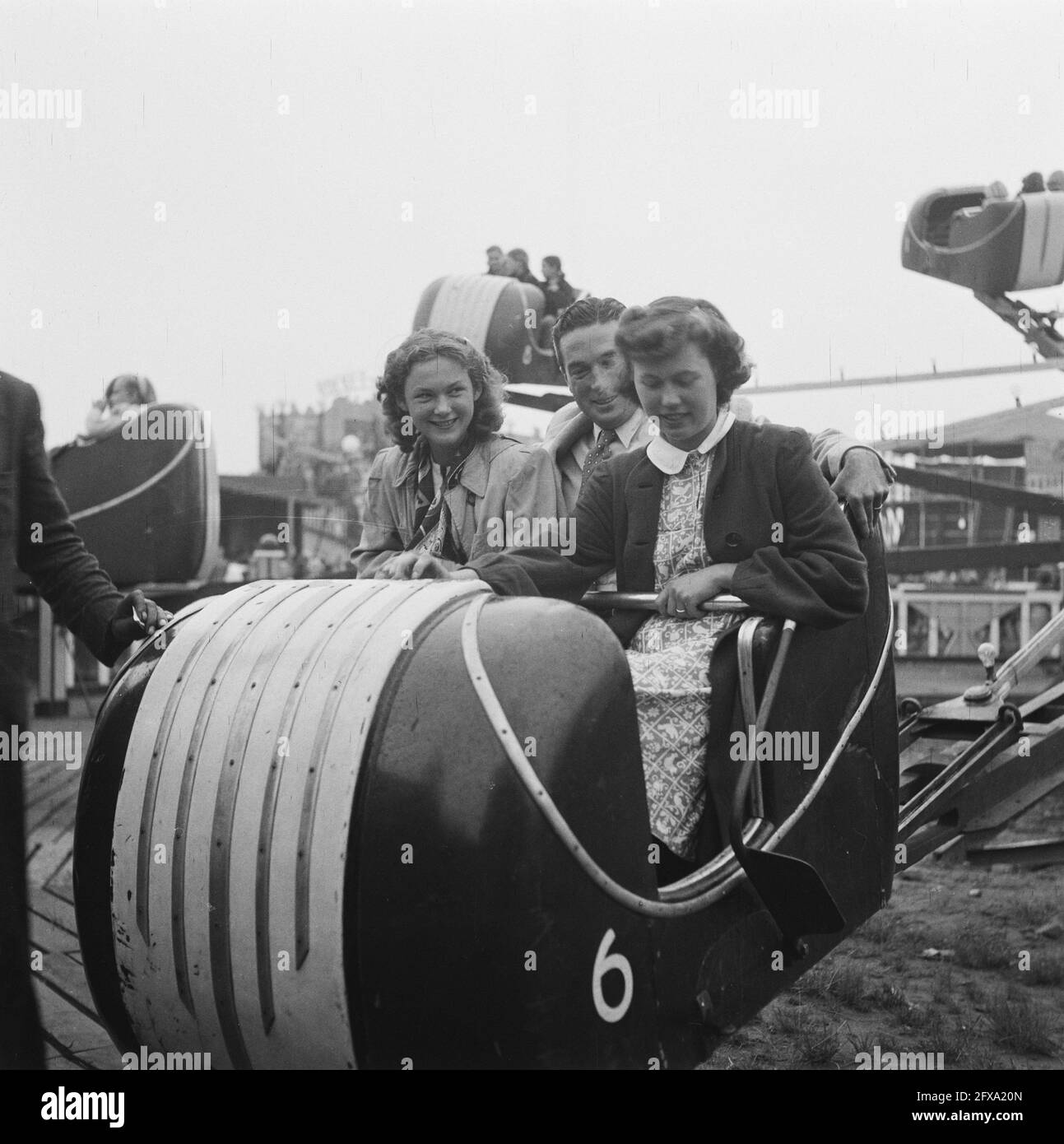 Fairground. Two young women and a young man in a fairground attraction ...