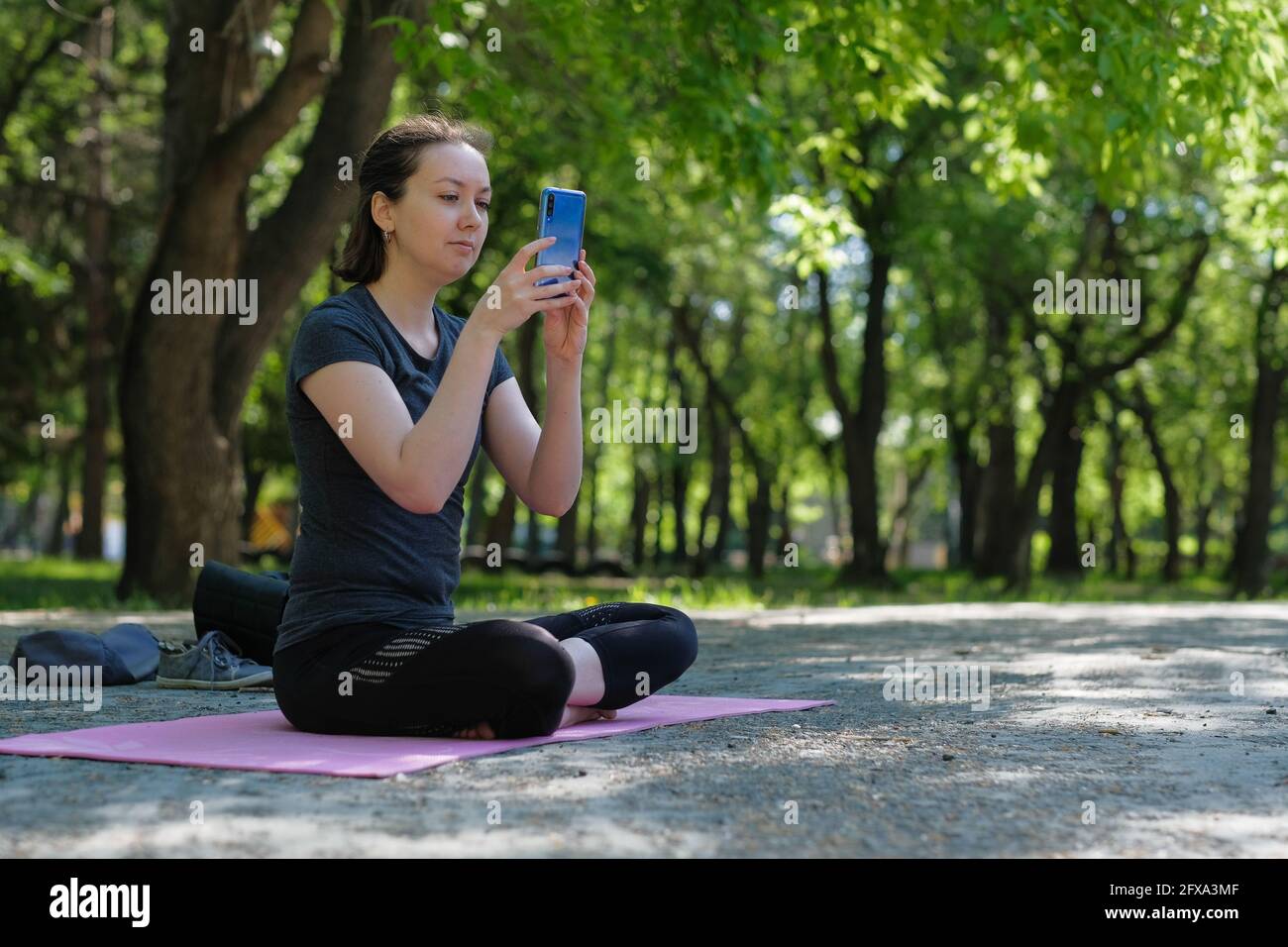 Brunette female use mobile phone on yoga lesson Stock Photo - Alamy