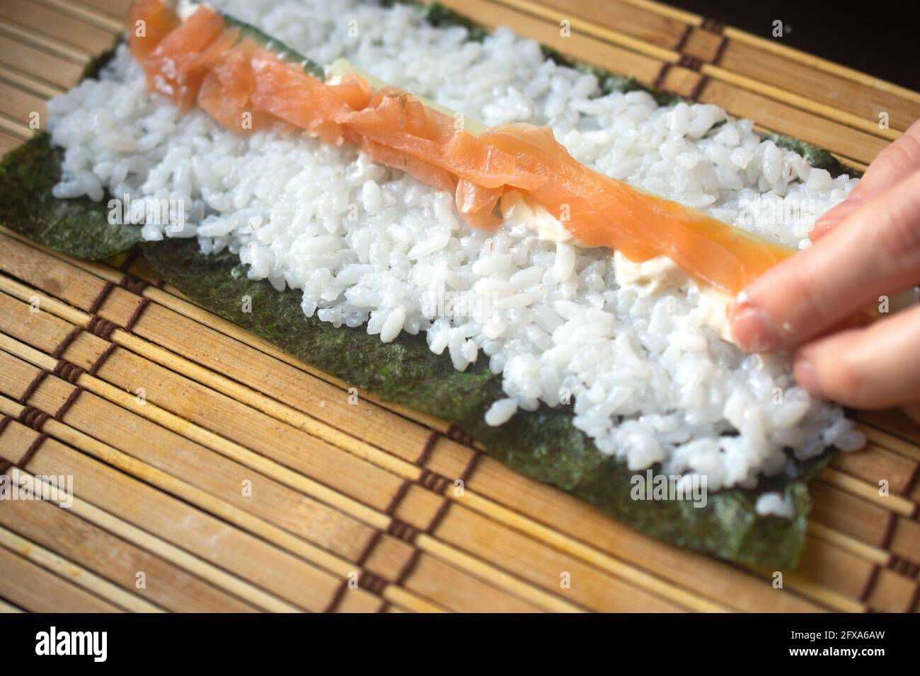 hands twist sushi rolls. close-up. japanese cuisine cooking method ...