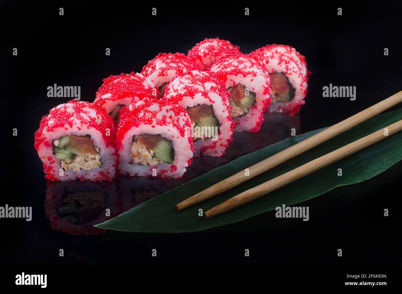 sushi roll with flying fish roe on black background Stock Photo - Alamy