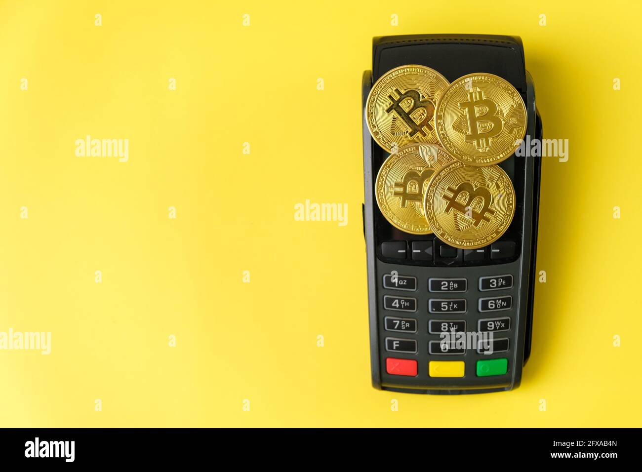 Bitcoin coins on the payment terminal on the yellow background Stock ...