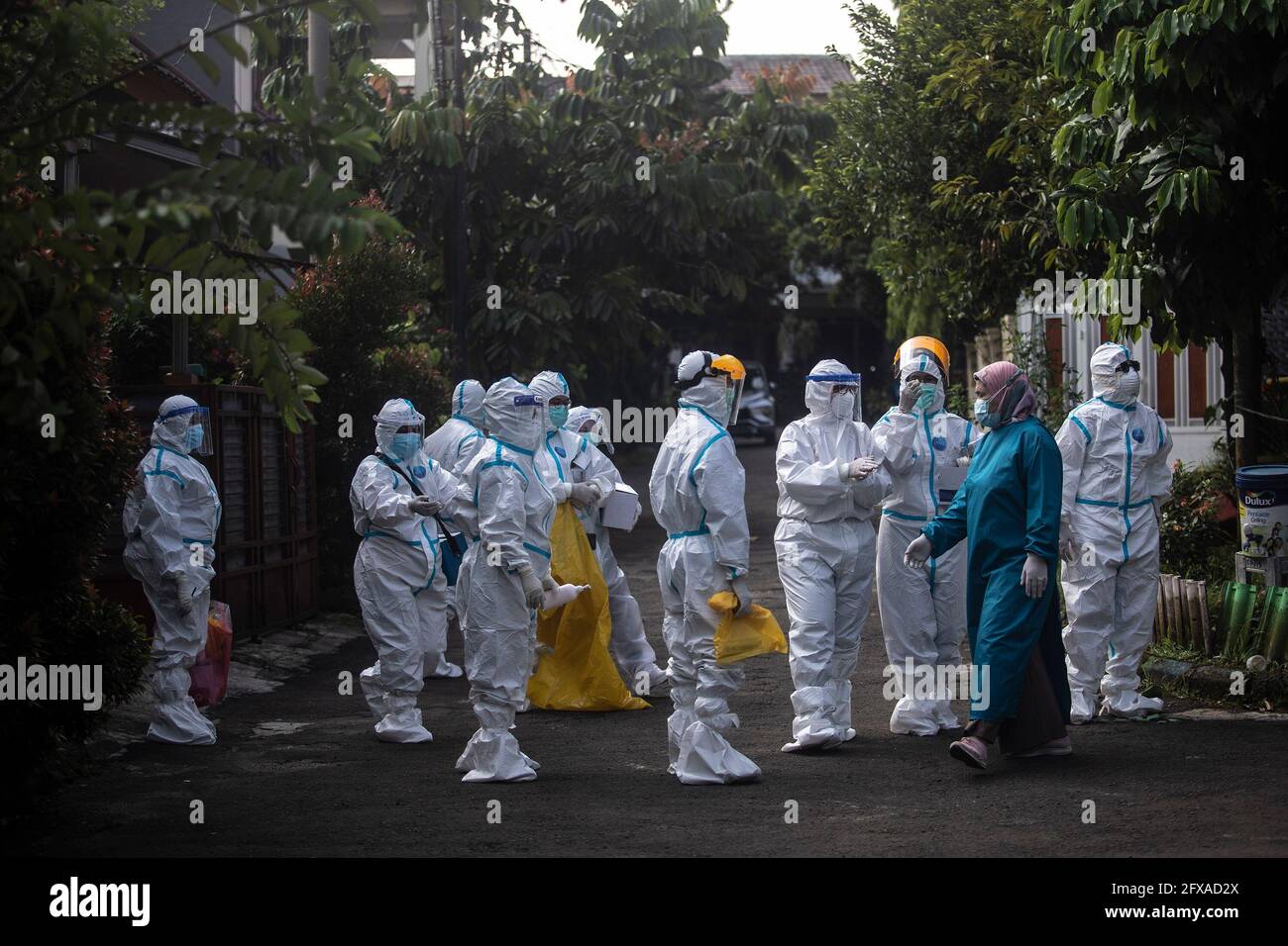Health workers wearing Personal Protective Equipment (PPE) walk around ...