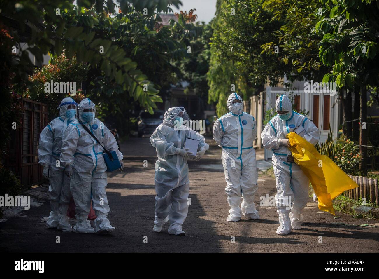 Health workers wearing Personal Protective Equipment (PPE) walk around ...