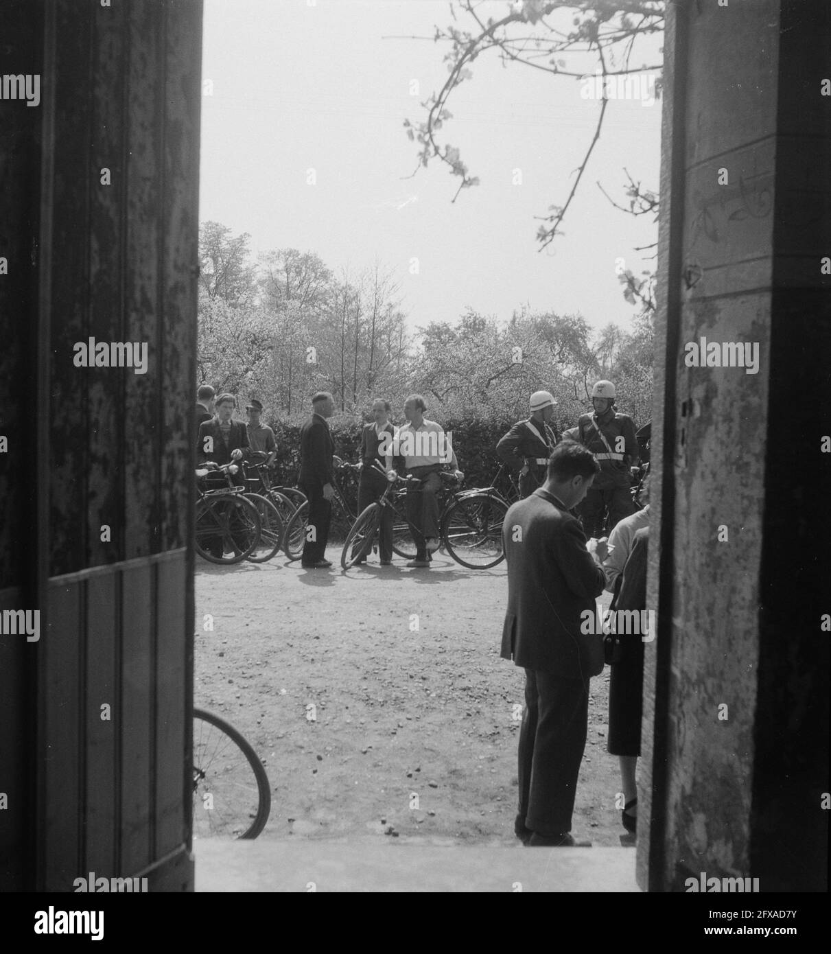 Vista of forecourt with men on bicycles and troopers, April 23, 1949 ...
