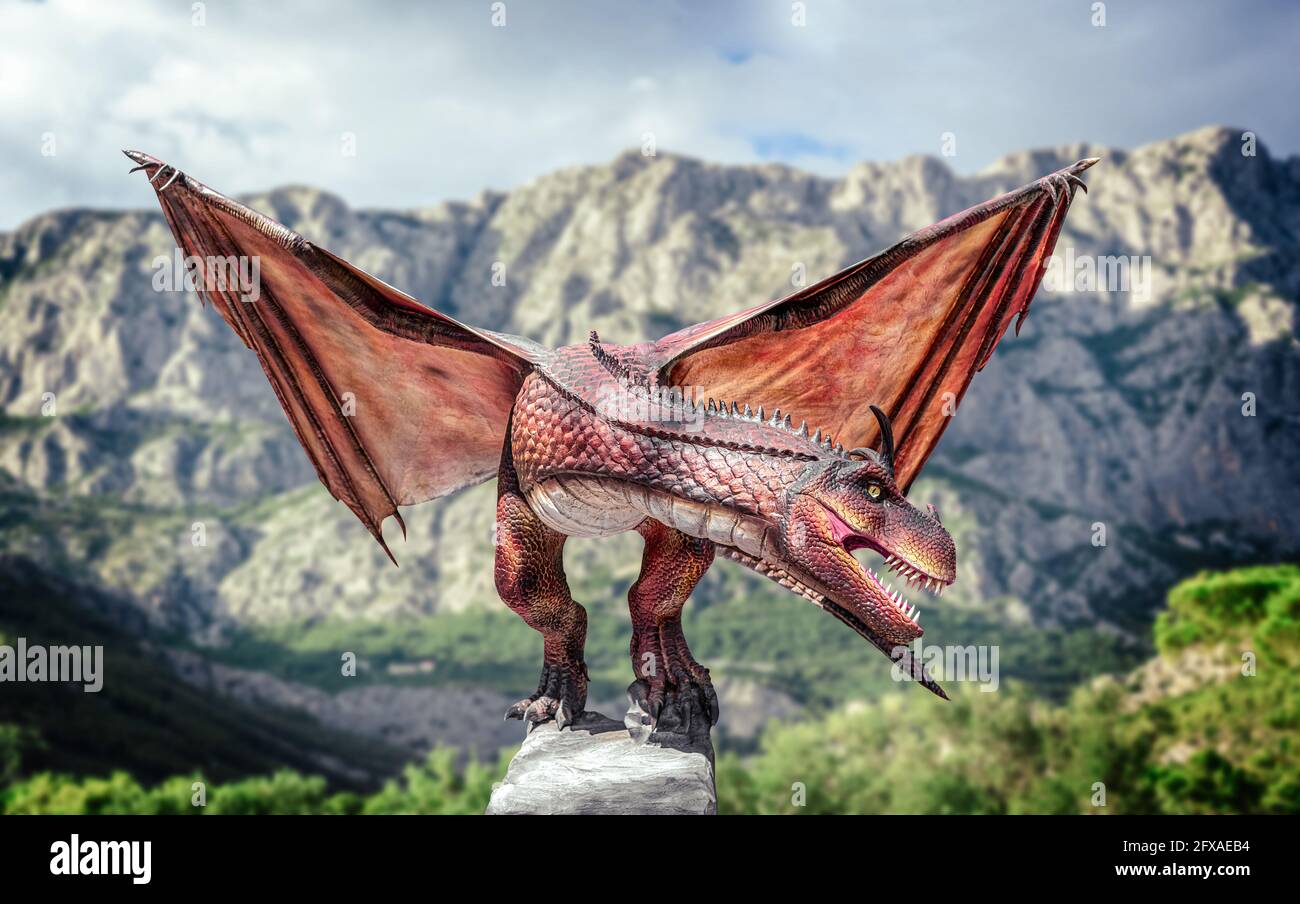 Dragon sitting on a rock Stock Photo - Alamy