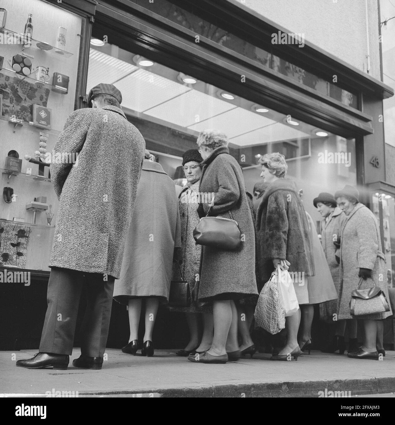 Bustle in the Amsterdam shopping streets. Shop window with thick roof ...