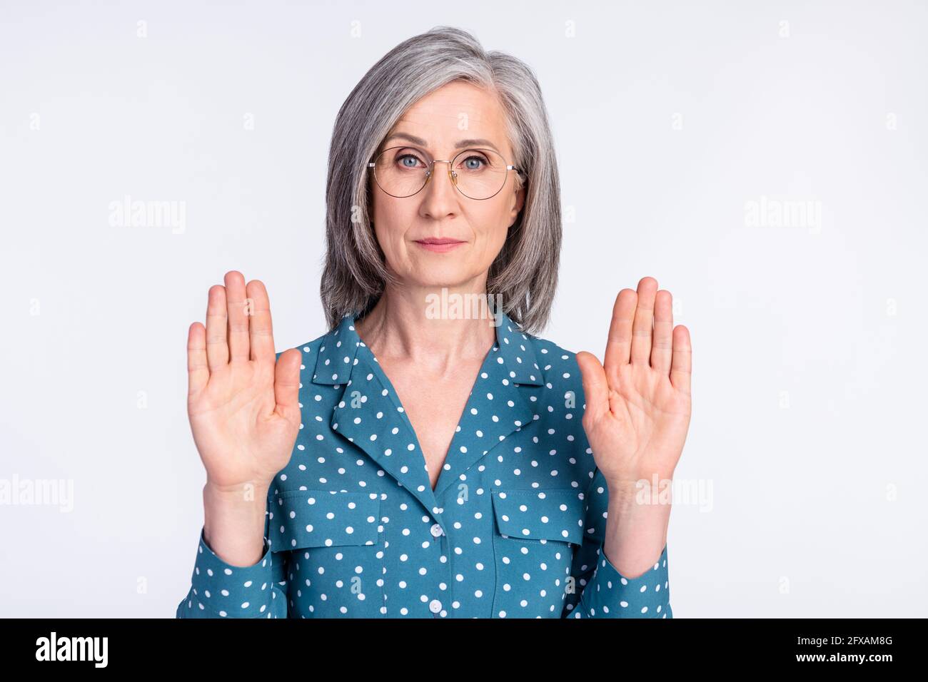 Portrait of attractive trendy elderly middle-aged lady showing palms ...