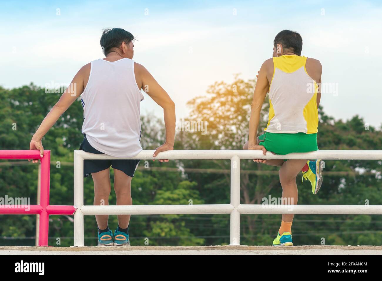 Two male friends sitting on fence hi-res stock photography and images ...