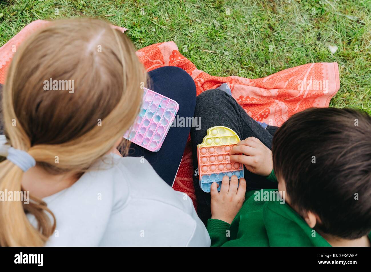 Kids with rainbow Pop It Fidget in hands. Teen in green Playing, Push ...