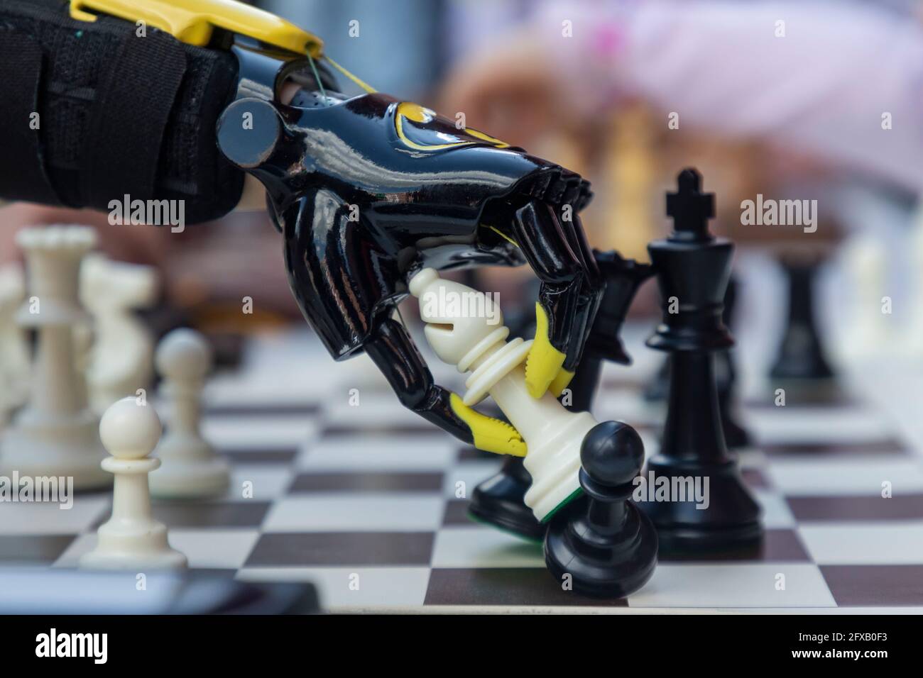 A boy with a bionic prosthetic arm plays chess Stock Photo - Alamy