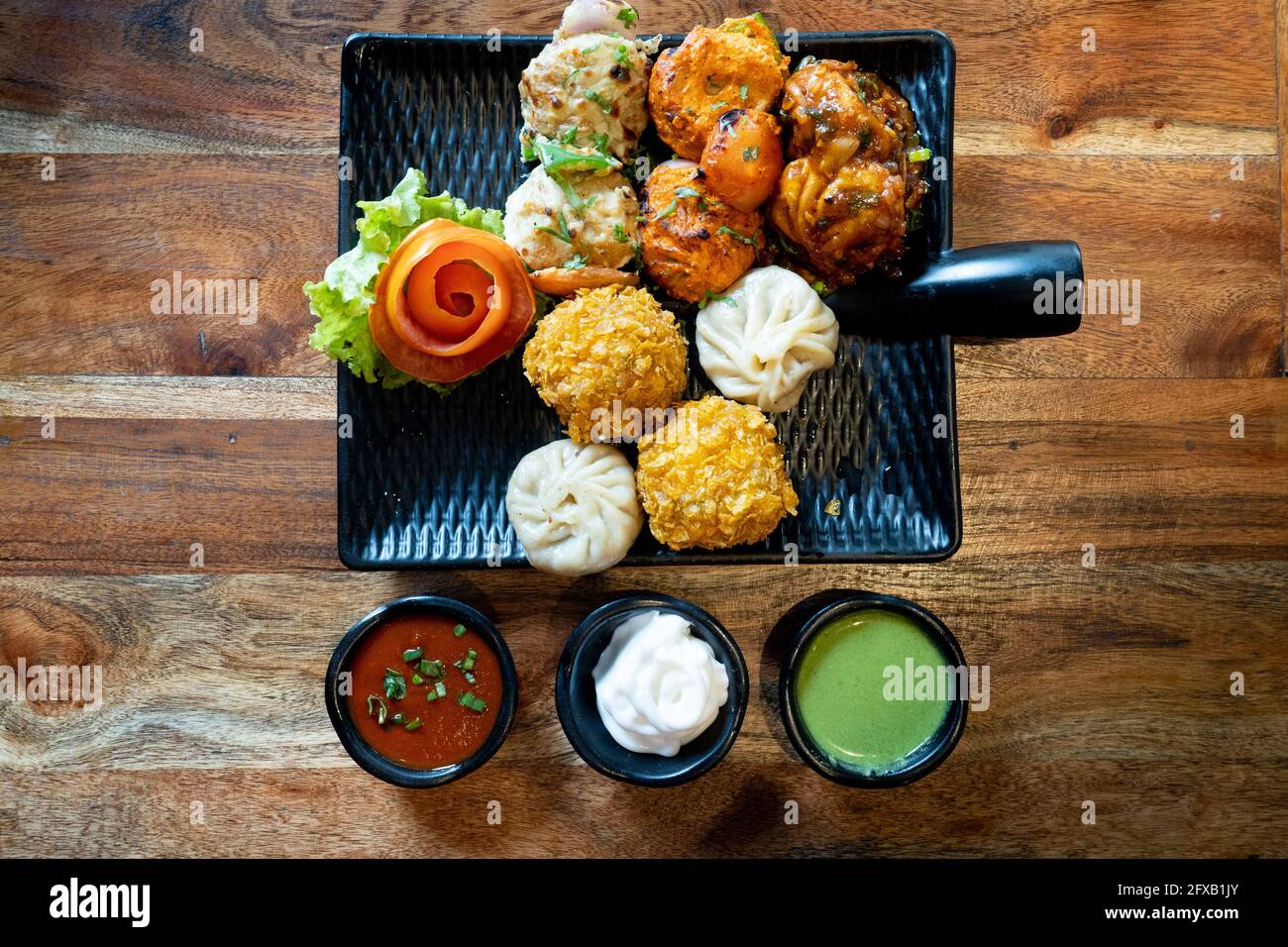 Top down flatlay shot of a momo platter with crispy tandoori fried ...