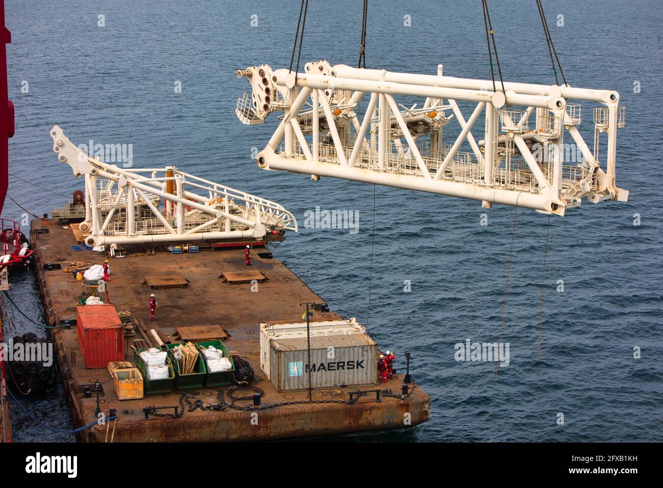 A pipeclay barge stinger is lifted off a materials barge in sections ...
