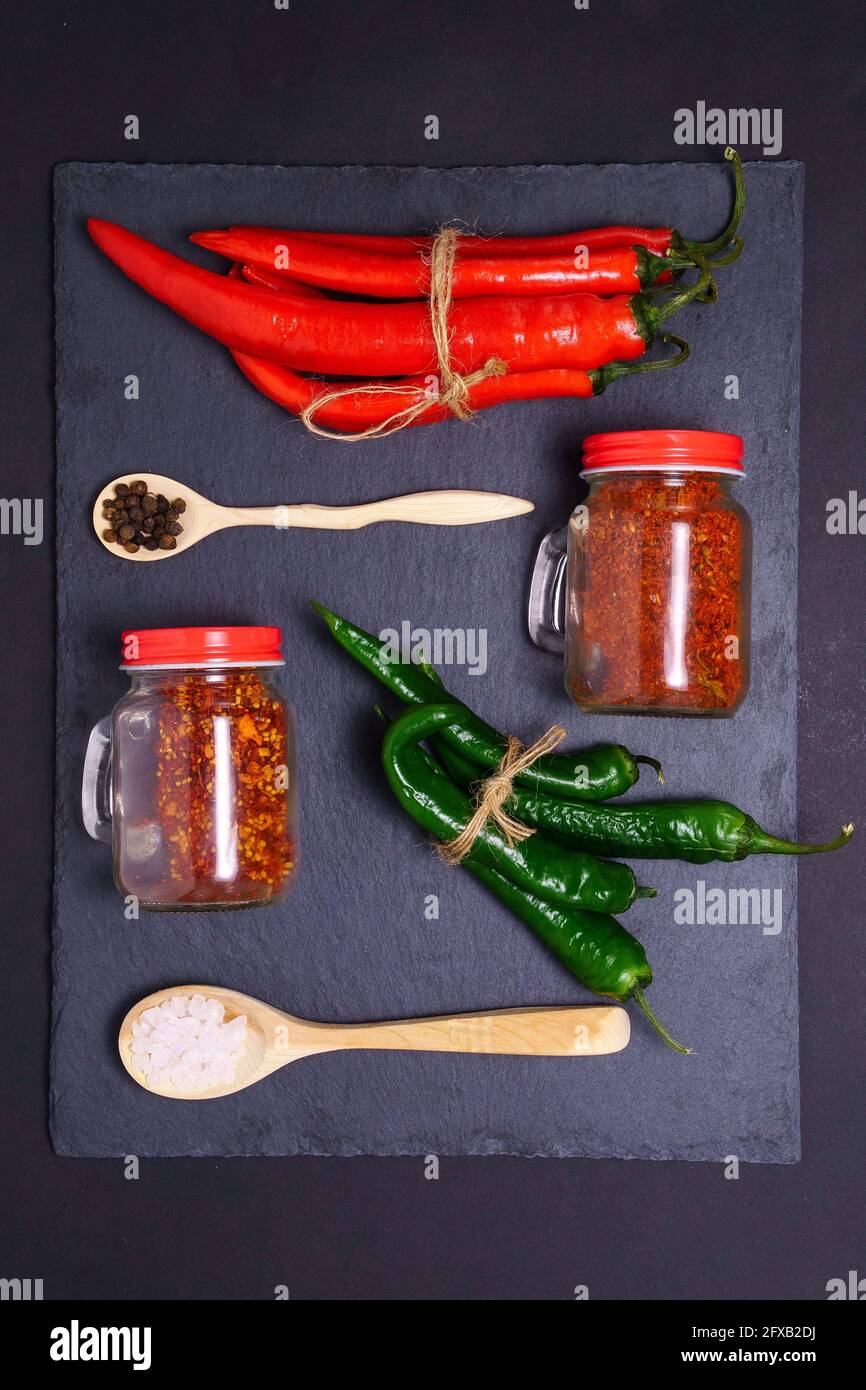 Red and green chili peppers. Hot spicy food ingredient. Dark slate ...