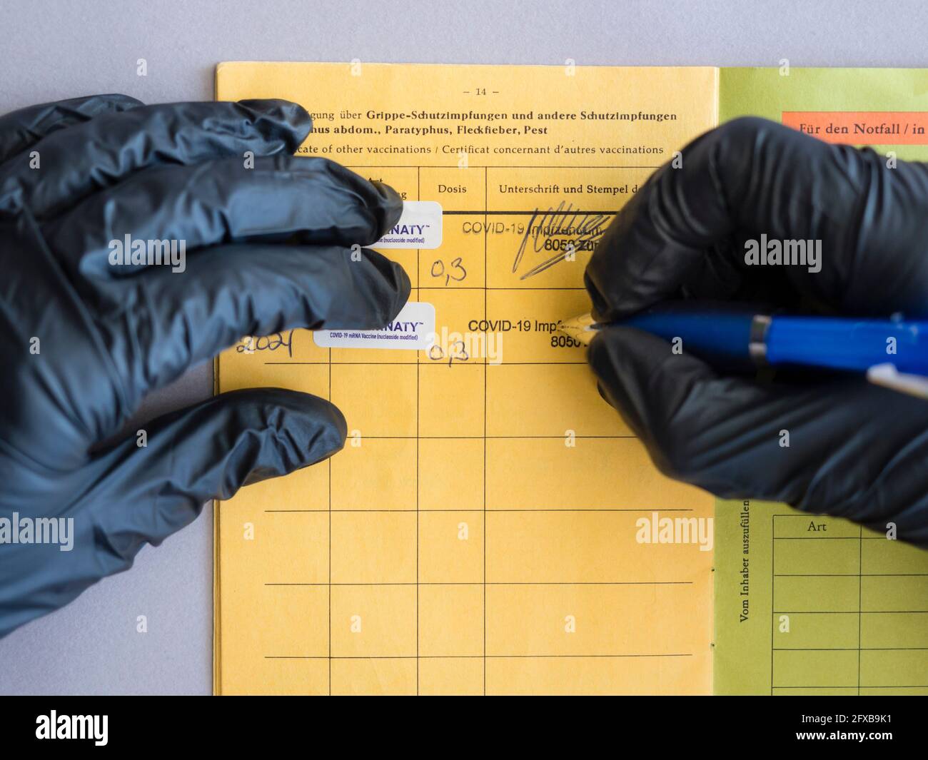 Zurich, Switzerland - 22 May 2021: A medical worker is signing an ...