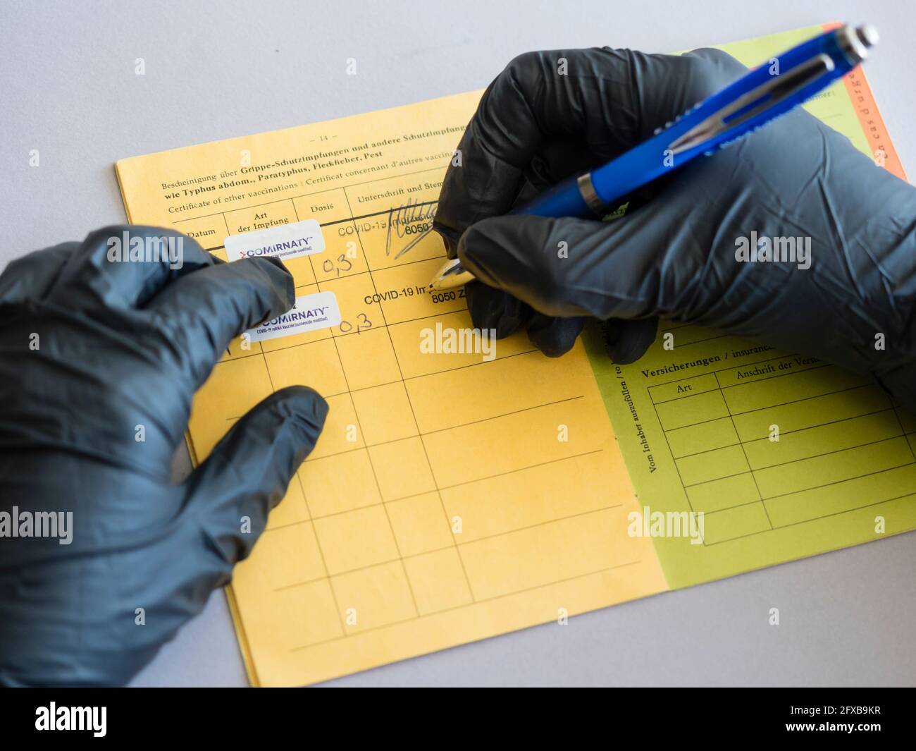 Zurich, Switzerland - 22 May 2021: A medical worker is signing an ...