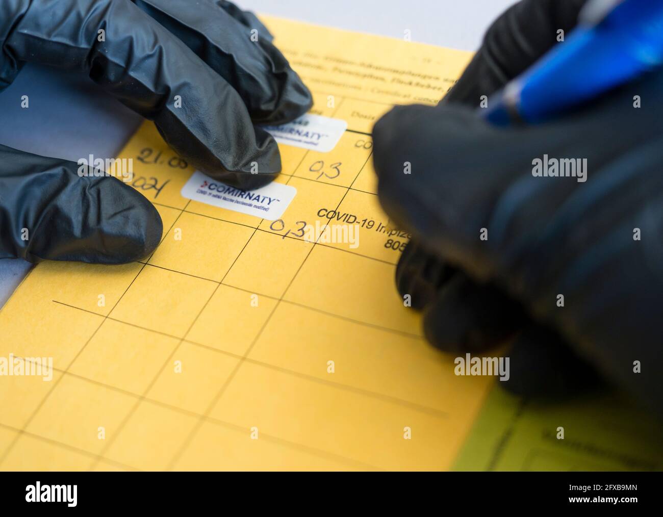 Zurich, Switzerland - 22 May 2021: A medical worker is signing an ...