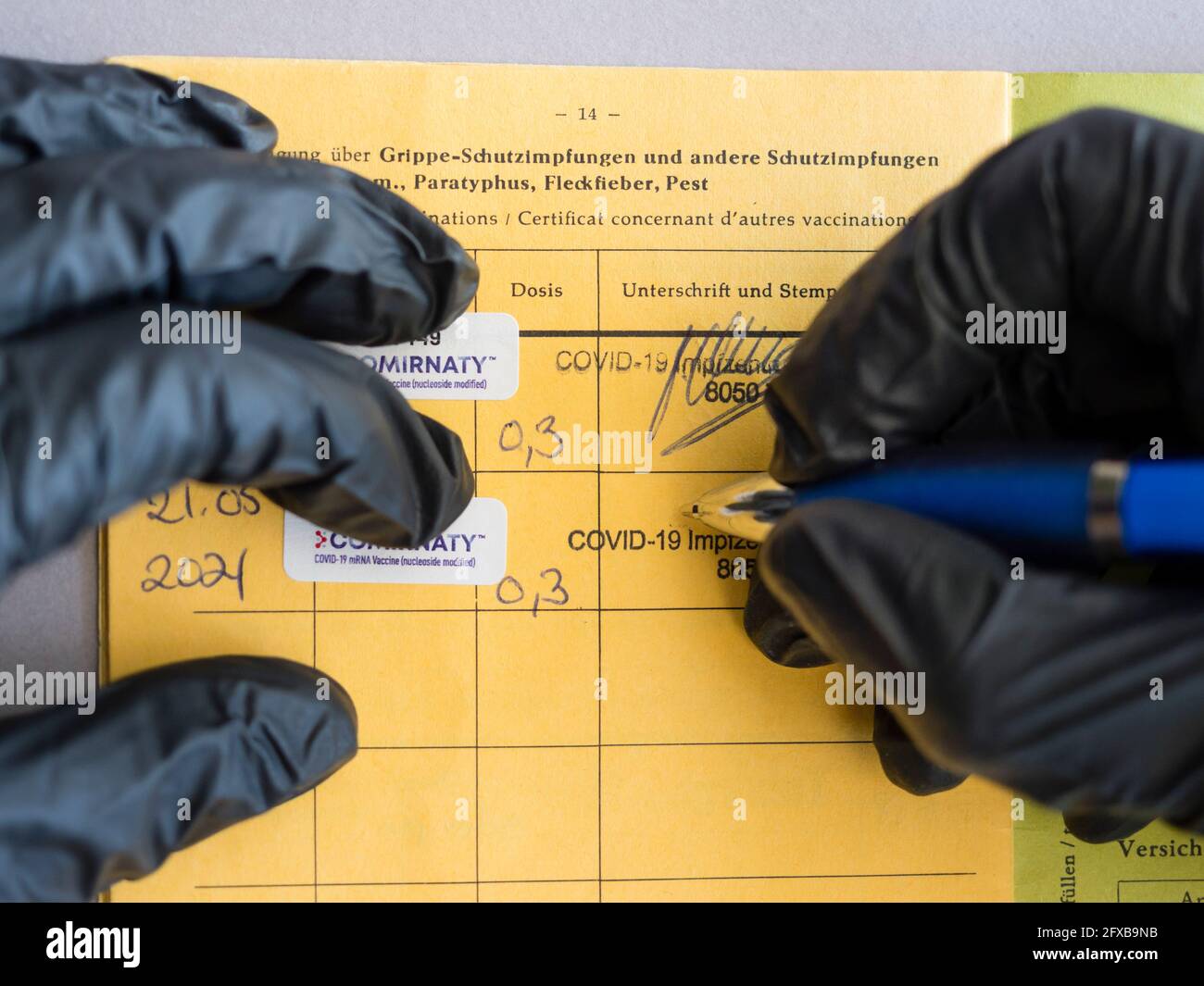 Zurich, Switzerland - 22 May 2021: A medical worker is signing an ...