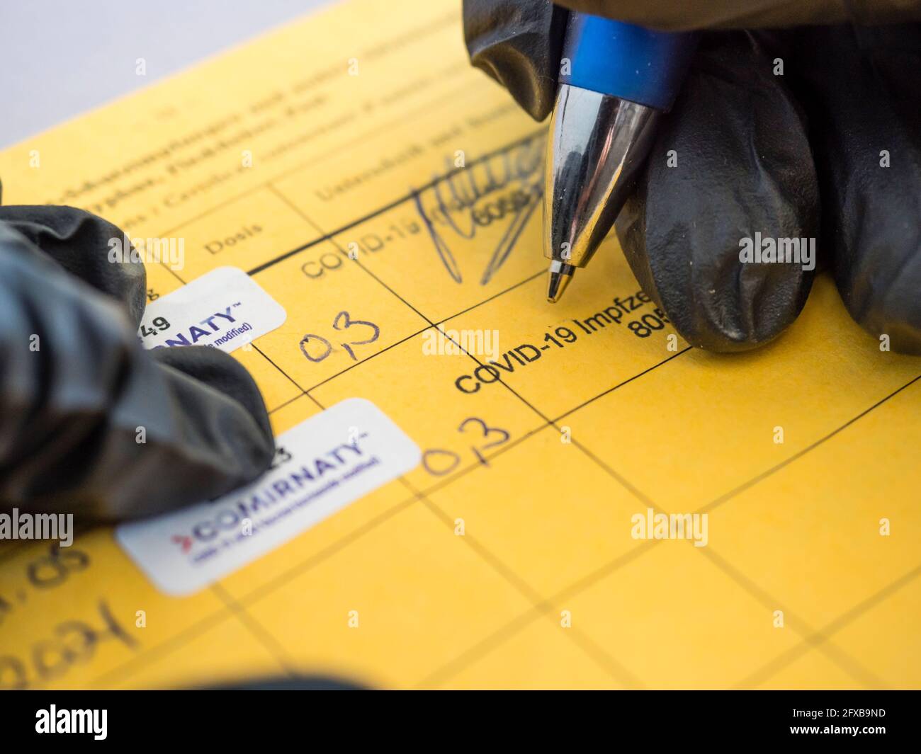 Zurich, Switzerland - 22 May 2021: A medical worker is signing an ...