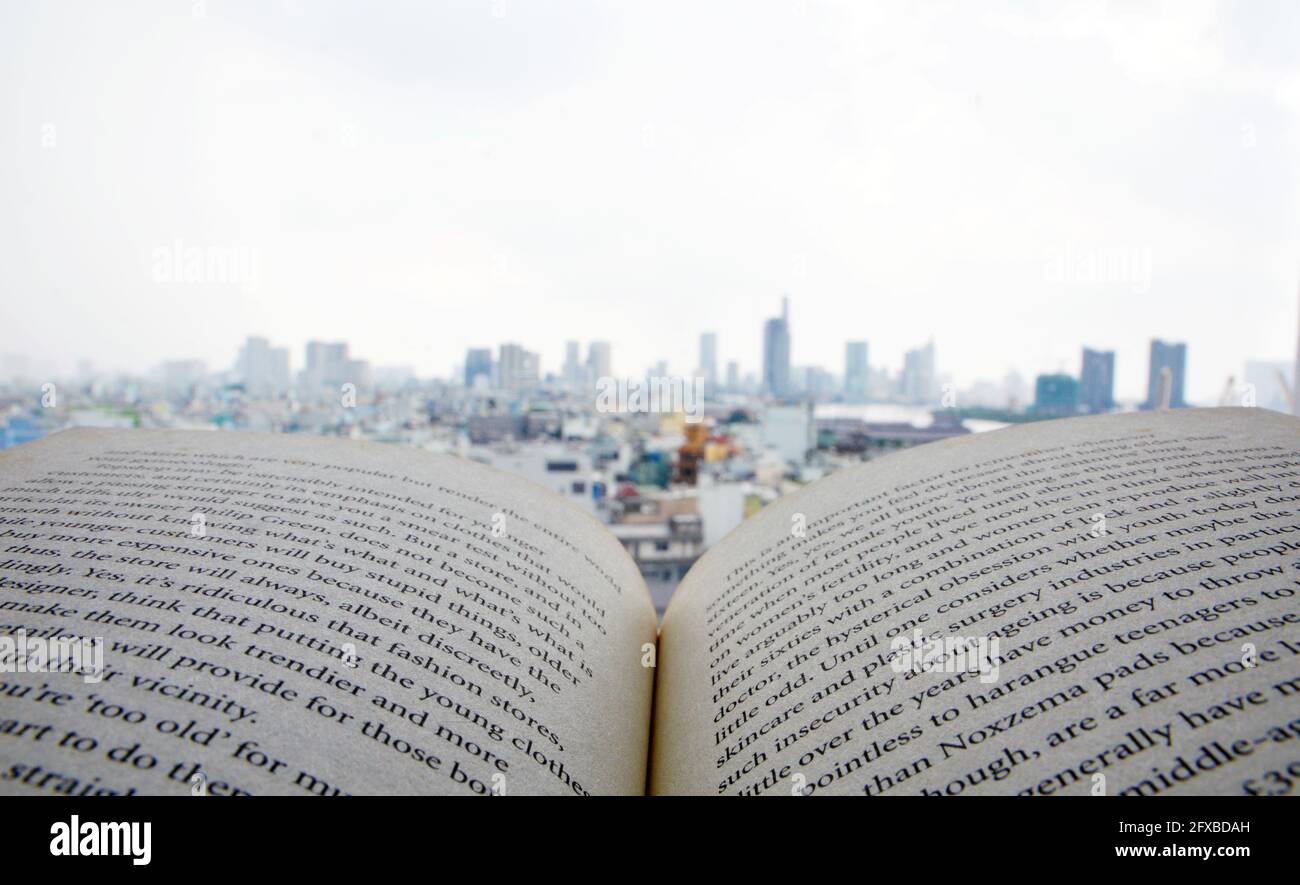 Open book with the background of city center skyscraper Stock Photo - Alamy