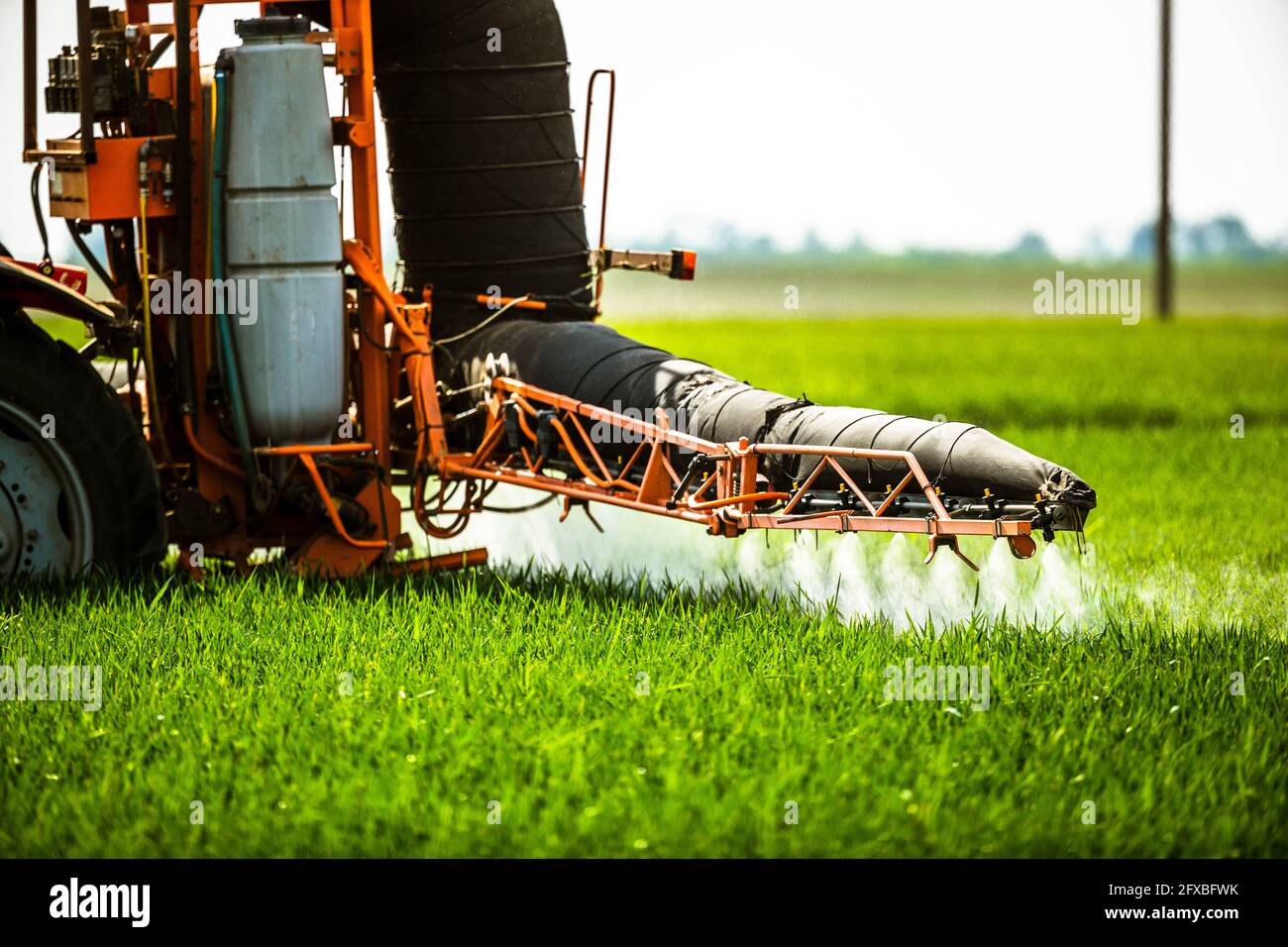 Crop sprayer sprinkling fertilizer on agricultural field Stock Photo ...