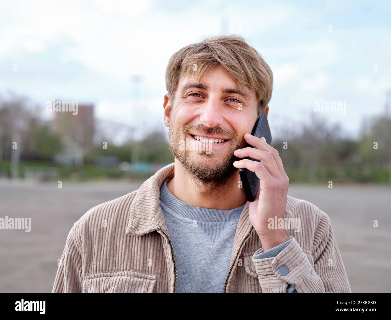 Smiling handsome man talking on mobile phone Stock Photo - Alamy