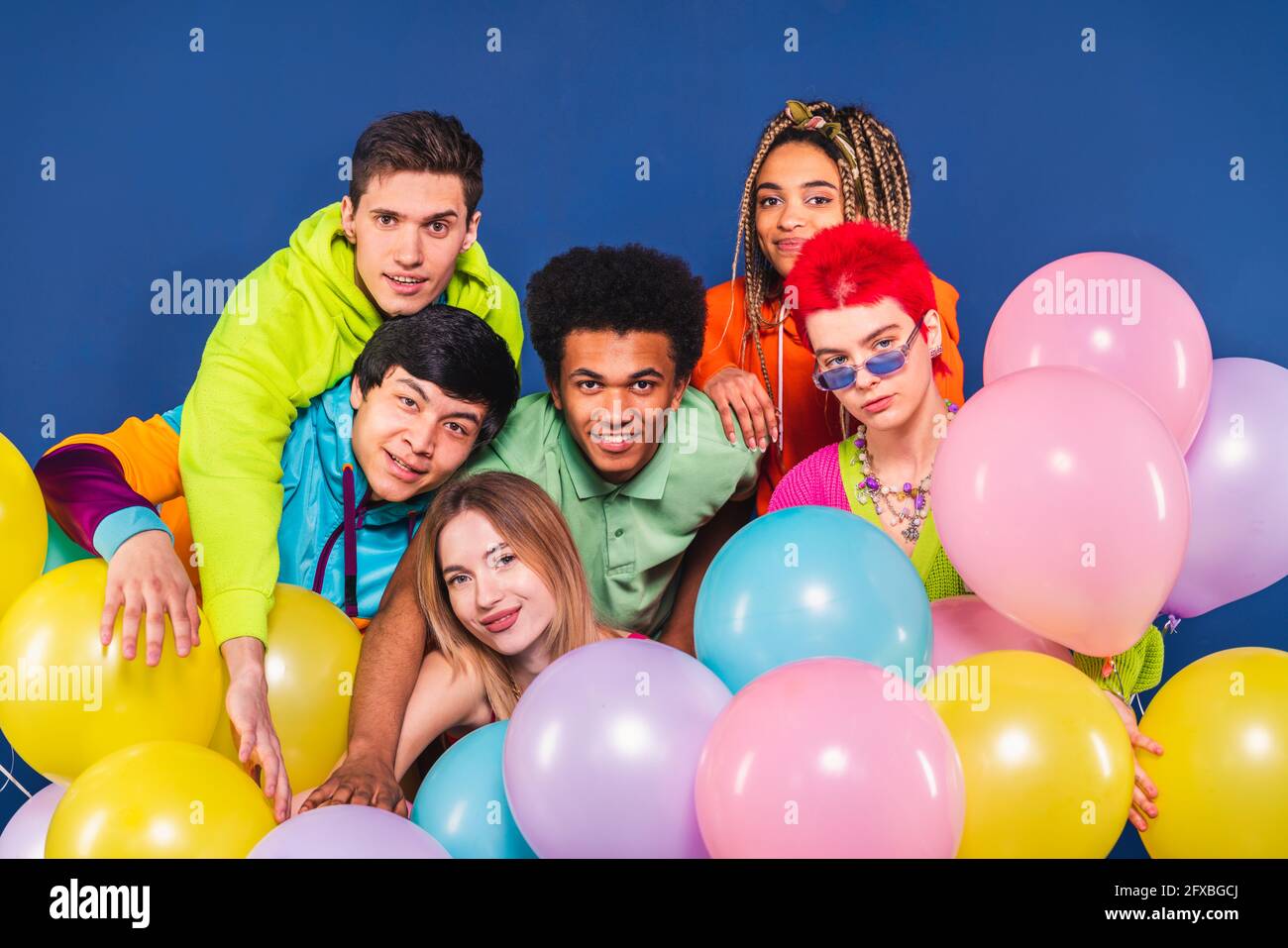Friends with balloon in front of blue background Stock Photo - Alamy