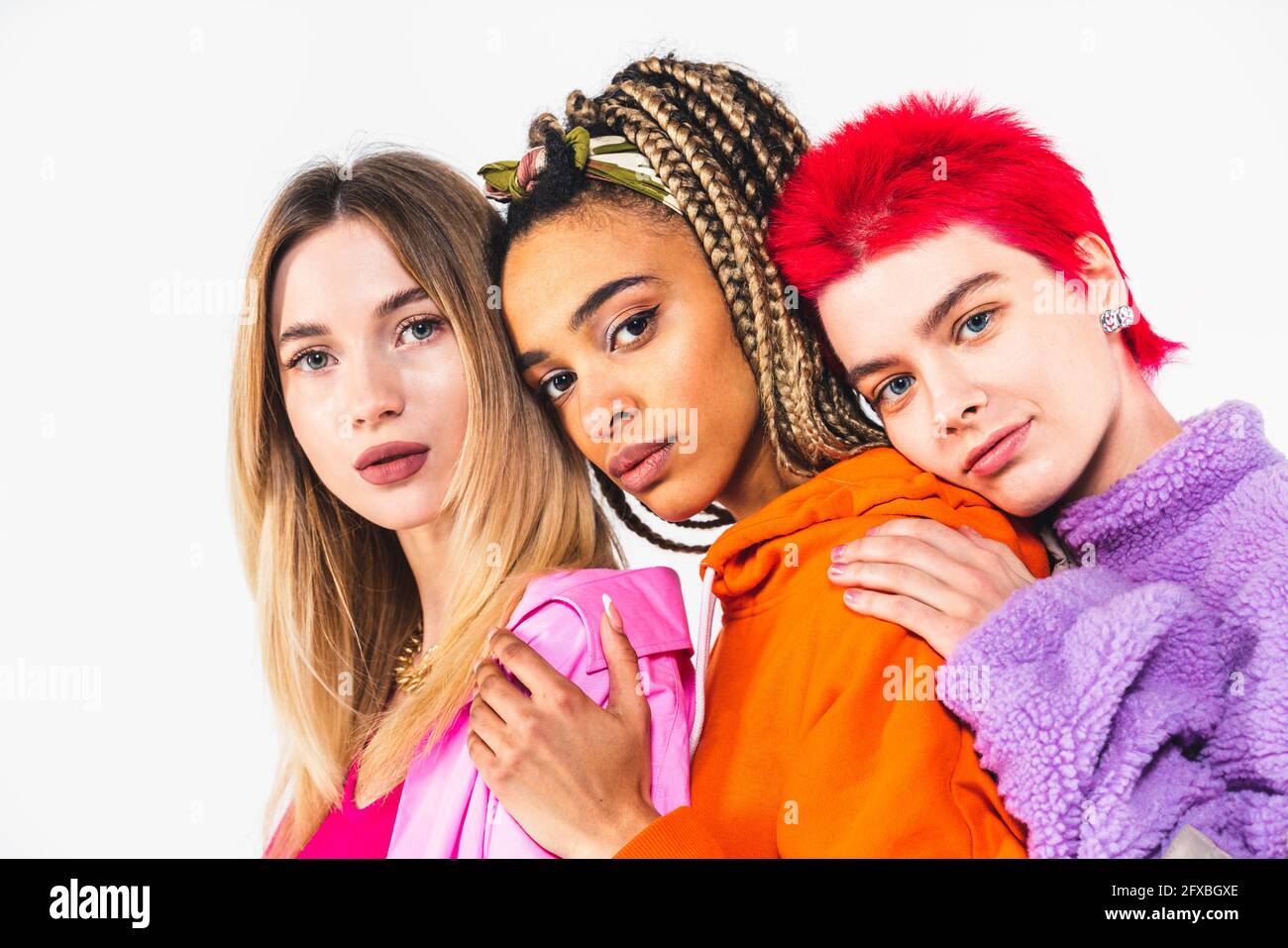 Beautiful female friends with hands on shoulder over white background ...