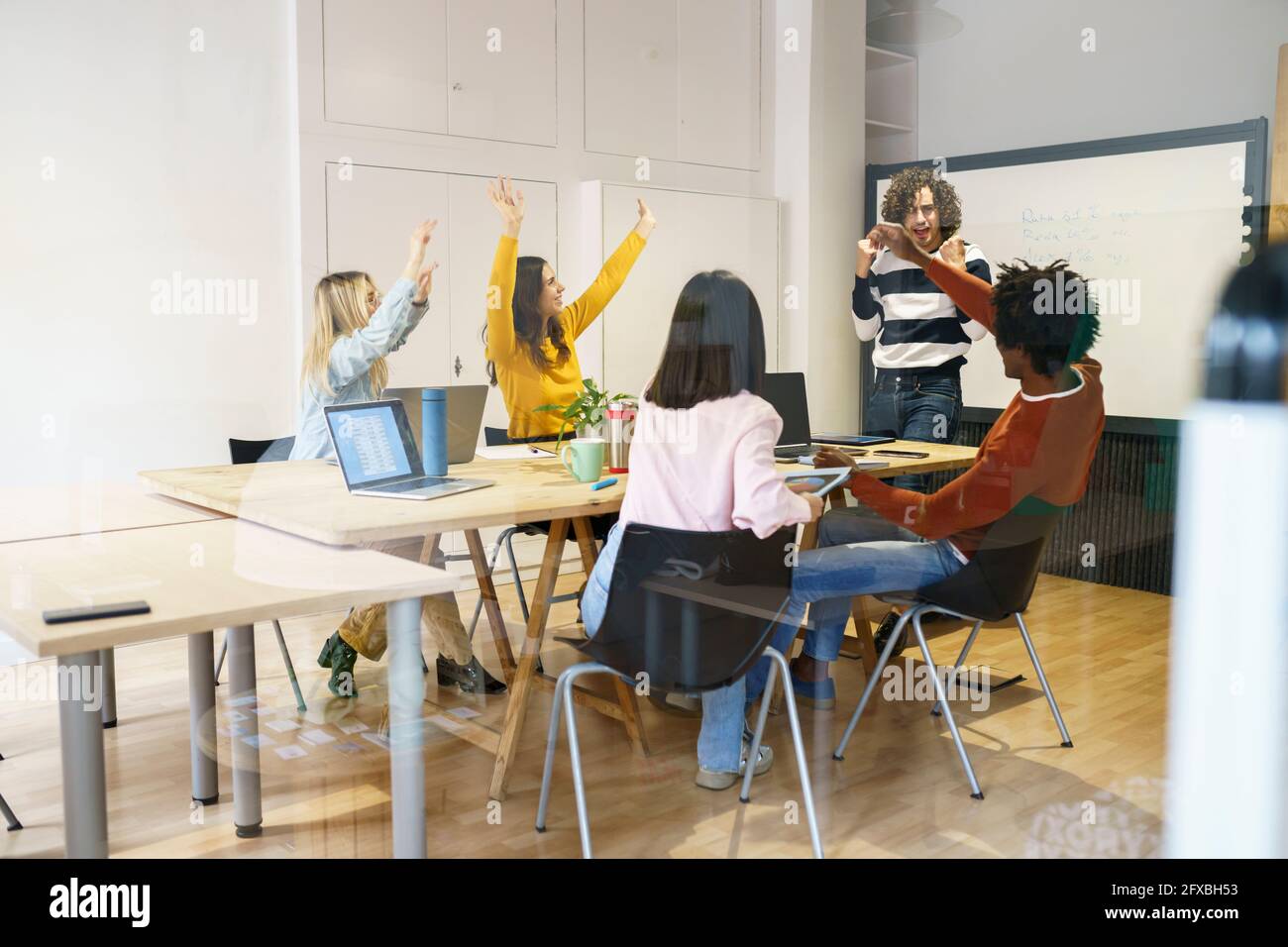 Happy multi-ethnic colleagues cheering in board room at office Stock ...