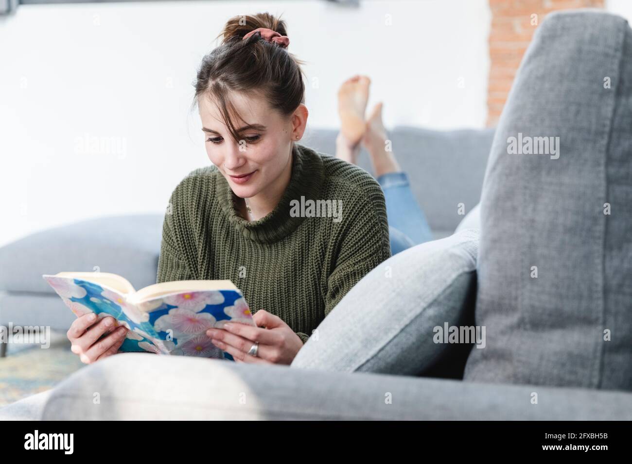 Woman reading on sofa hi-res stock photography and images - Alamy