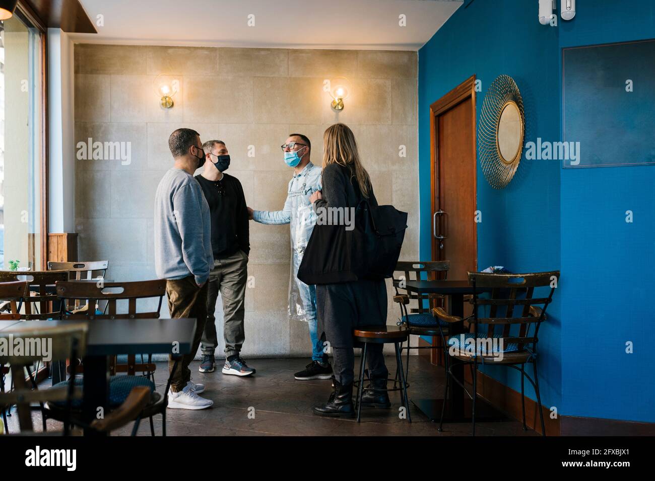Waiter talking to customers at a bar during COVID-19 Stock Photo - Alamy