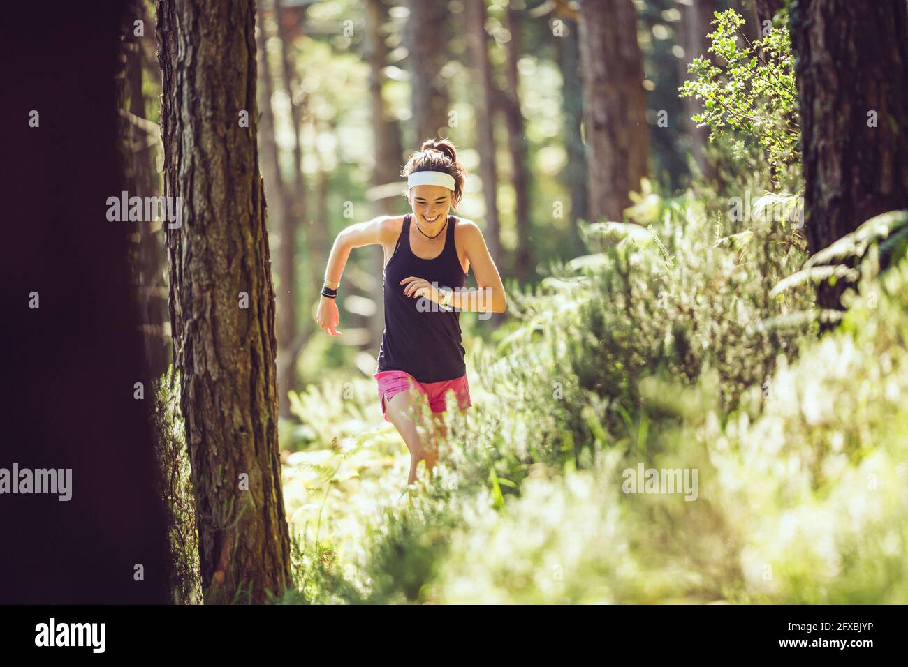 Active female athlete running in forest Stock Photo - Alamy