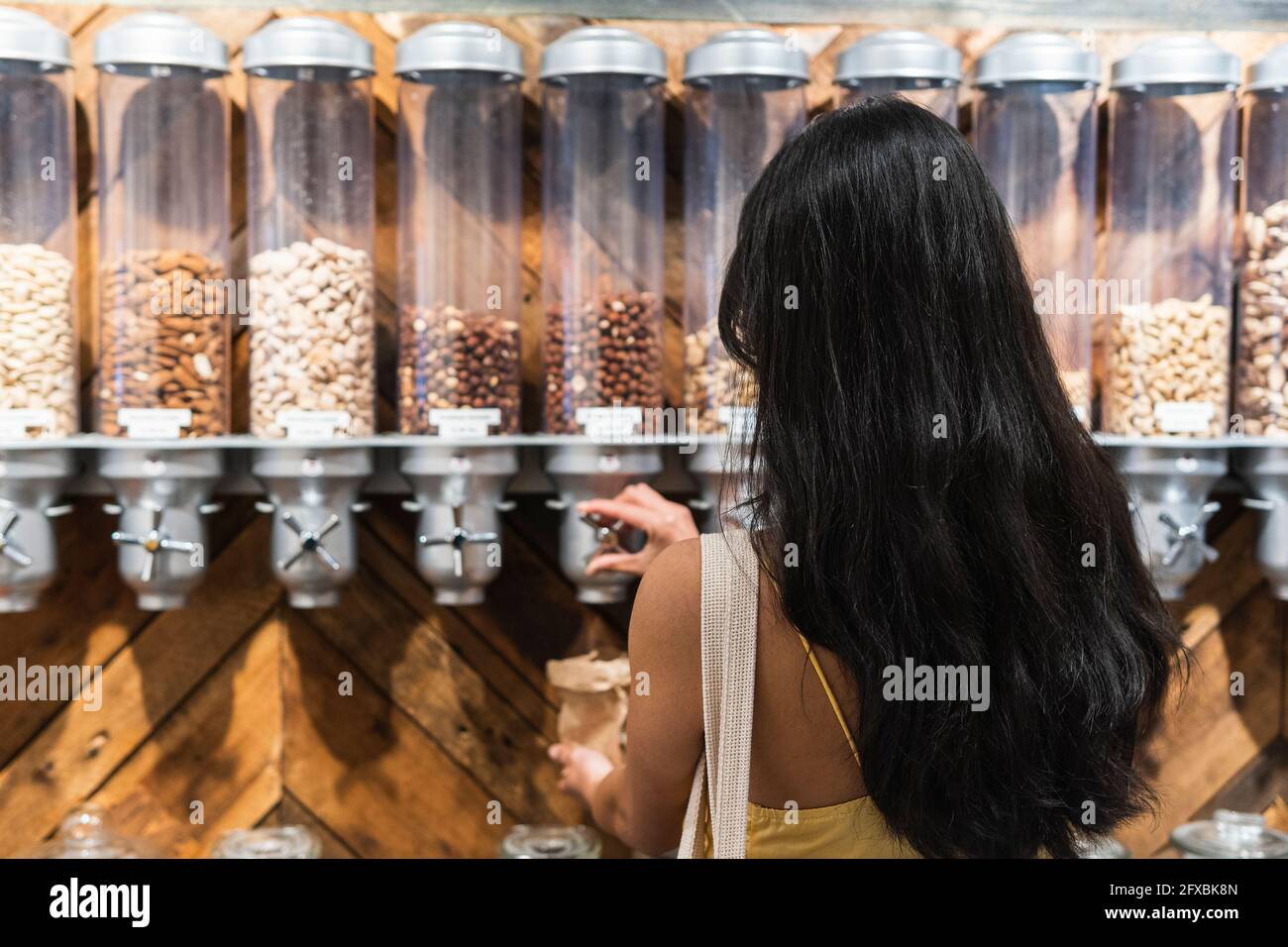 Woman with black hair buying nuts at grocery store Stock Photo - Alamy