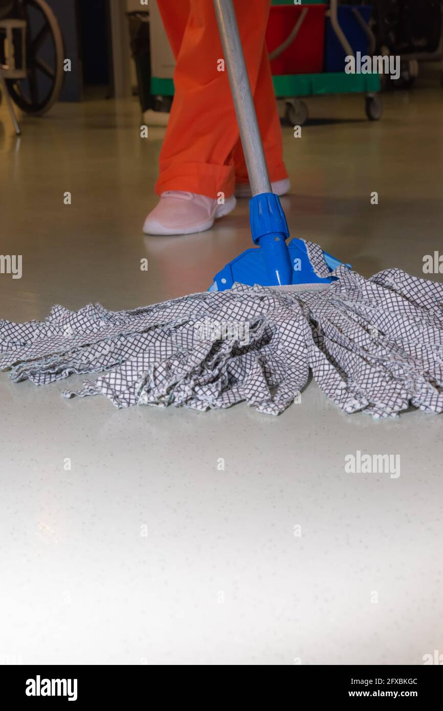 Mop in the foreground cleaning the floors of an operating room with the ...