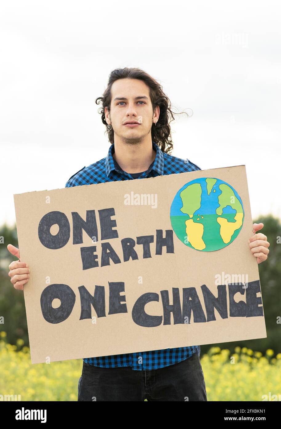 Man holding climate change poster in front of sky Stock Photo - Alamy