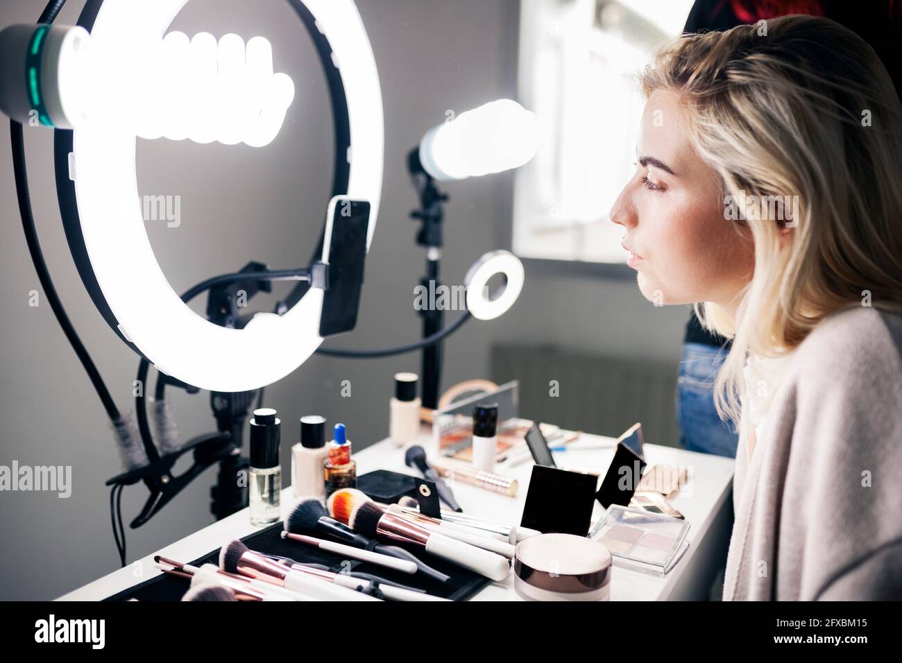 Female model vlogging through mobile phone at studio Stock Photo - Alamy