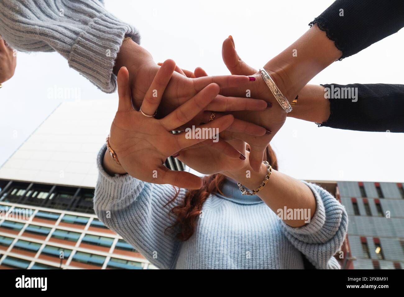 Young female friends stacking hands Stock Photo - Alamy