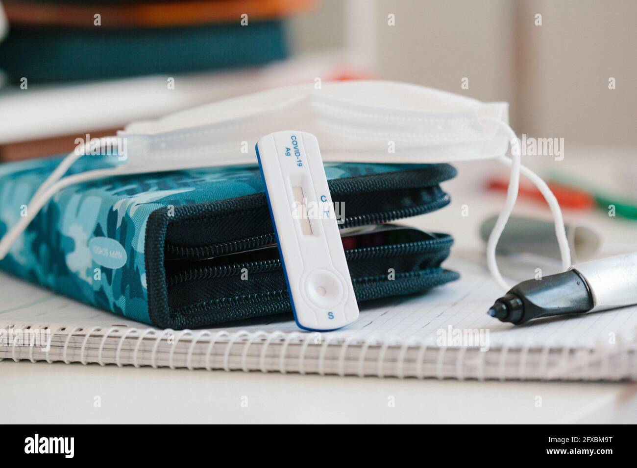 Rapid diagnostic test kit with protective face mask over pencil case at ...