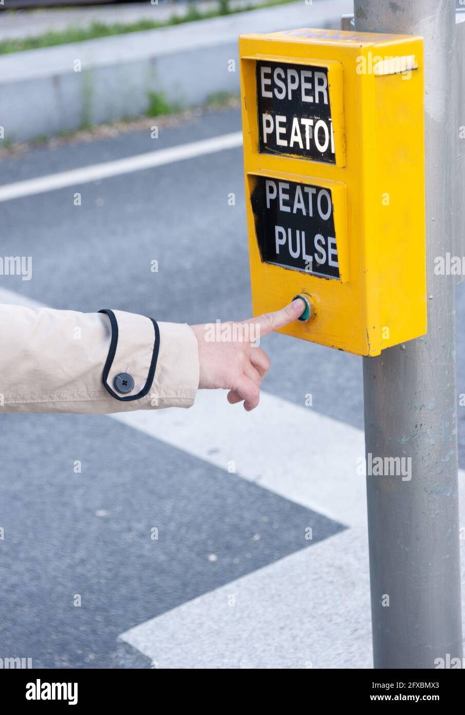 Woman's finger pressing the pedestrian button of a traffic light. The ...