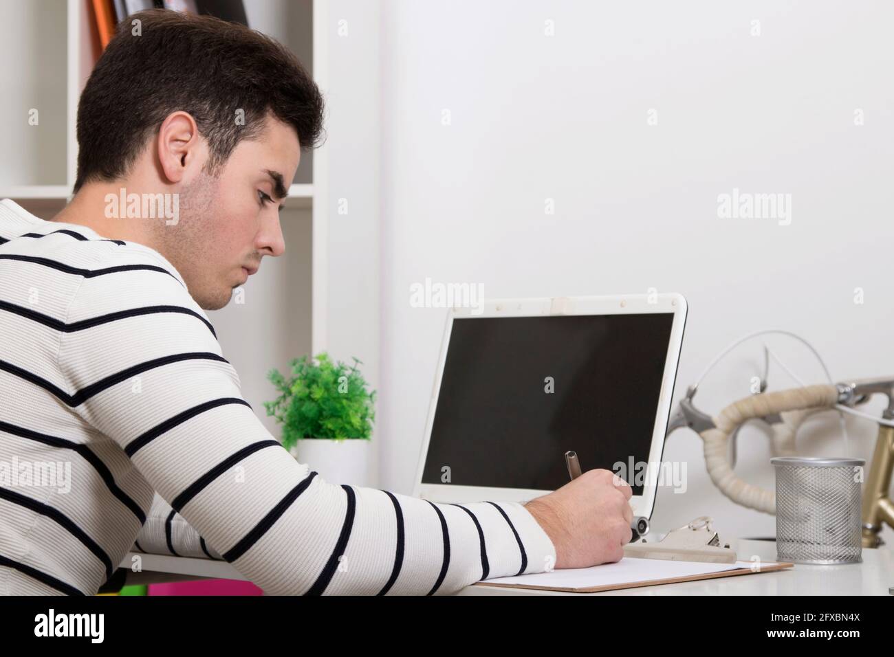 young man studying at home on your desktop with laptop computer Stock ...