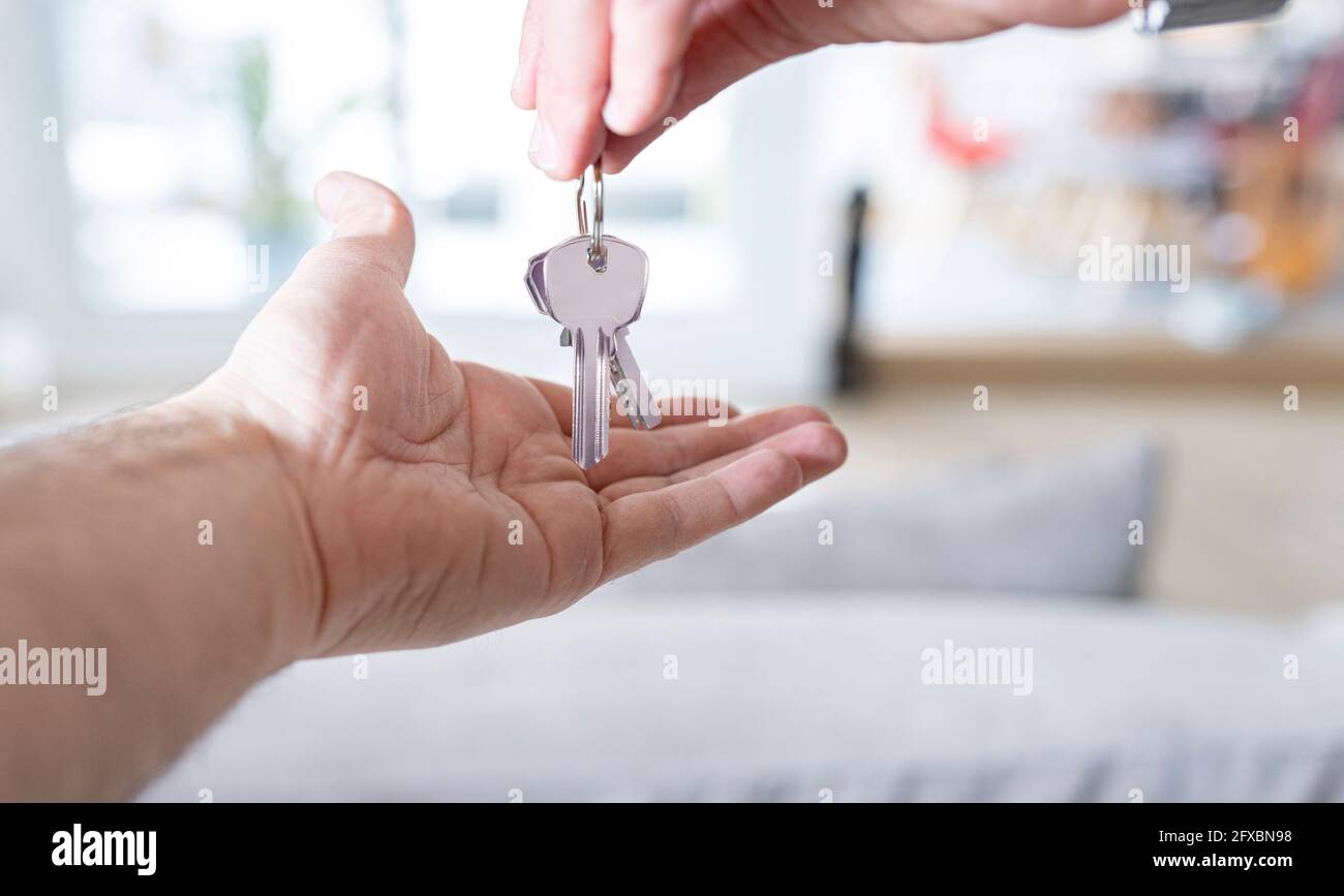 Hand handing over house keys Stock Photo - Alamy