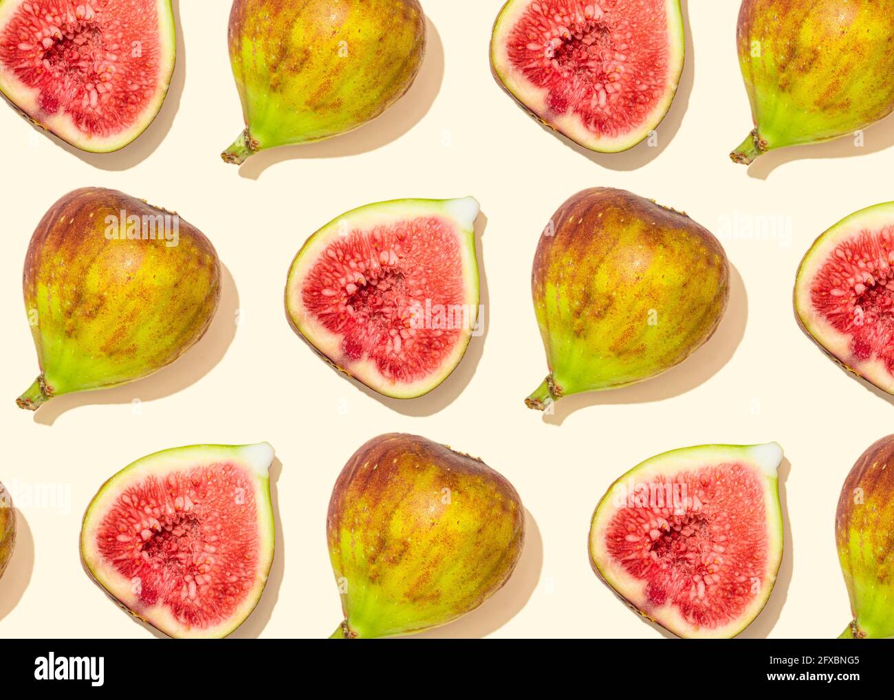 Pattern of halved figs flat laid against light yellow background Stock ...