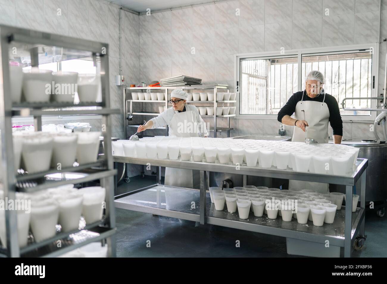 Chefs preparing cheese in containers at kitchen Stock Photo - Alamy