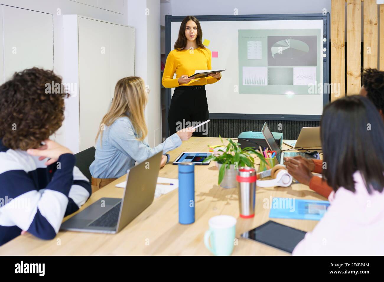 Female professional discussing over projection screen in meeting at ...