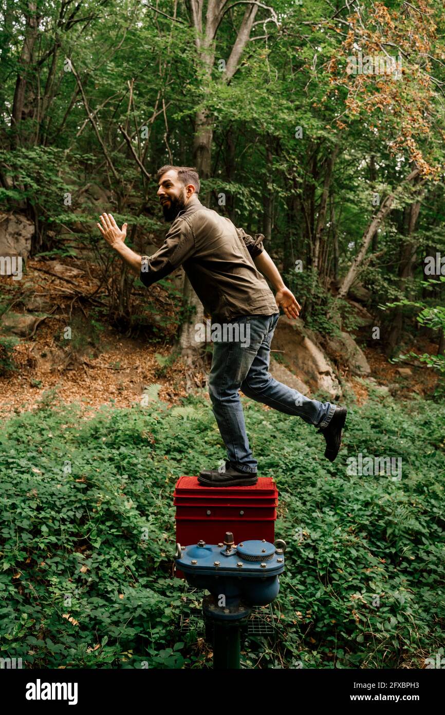Man standing on top of hydrant in forest Stock Photo - Alamy