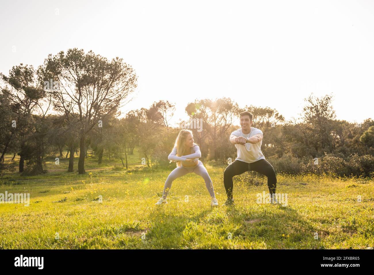 Sports people exercising together at grass area Stock Photo - Alamy