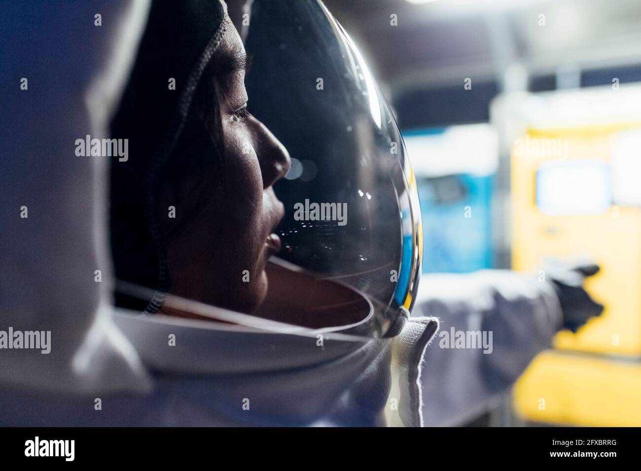 Female astronaut with space helmet pointing during night Stock Photo ...