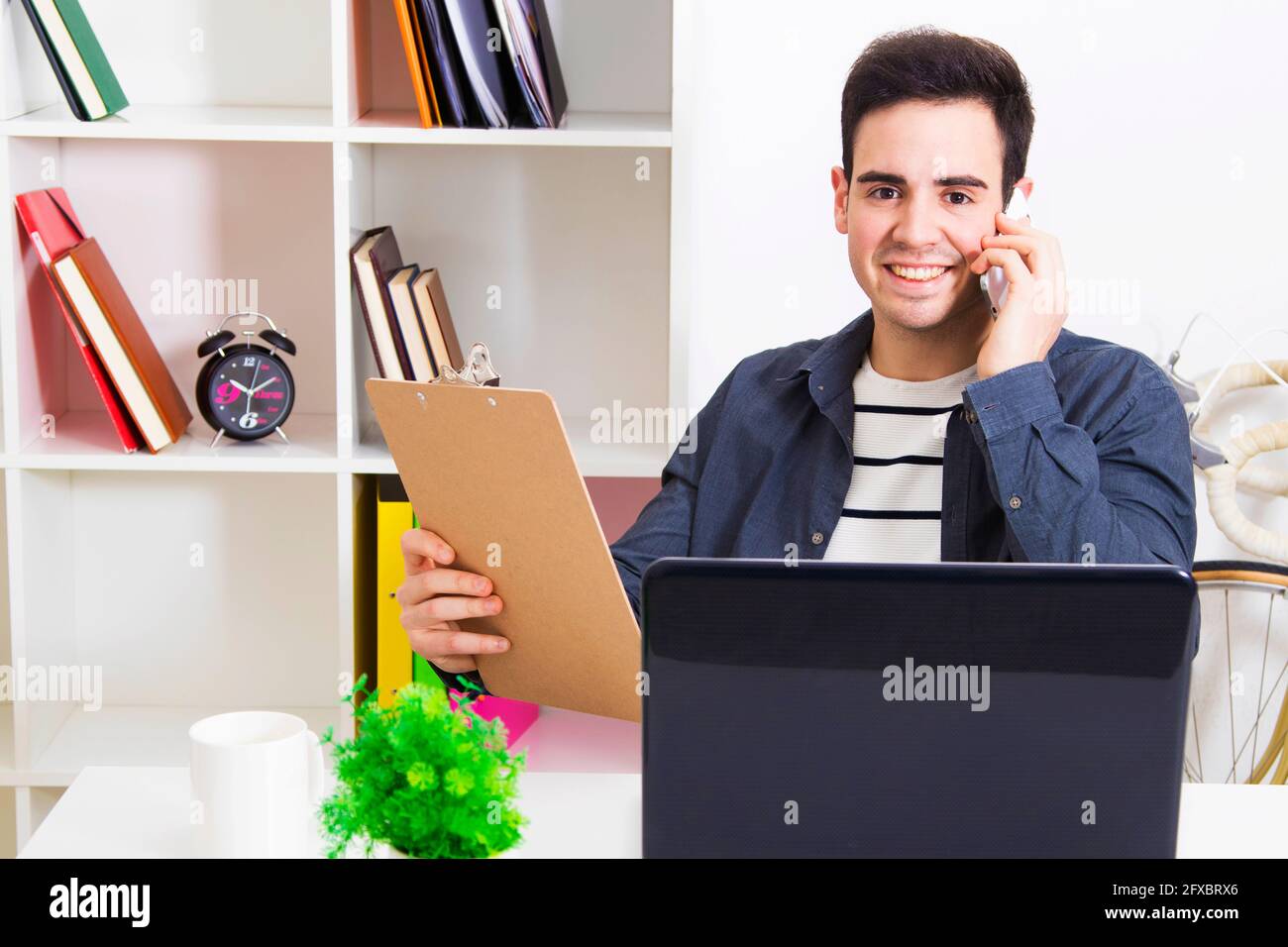 man talking by phone mobile in front of the computer in the office or ...